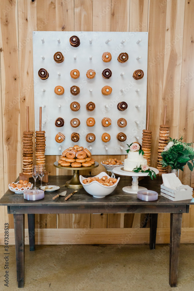 Wedding Reception Dessert Table with a Donut Wall with Donut Holes on ...