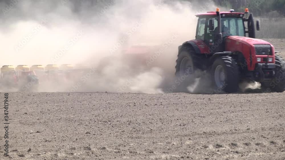 Tractor cultivating field at spring. Closeup of planter in farm field ...