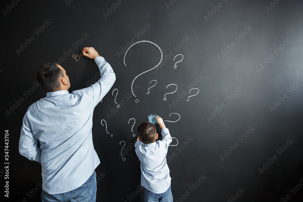 Little boy and his dad draw question marks on the Board. Concept for ...