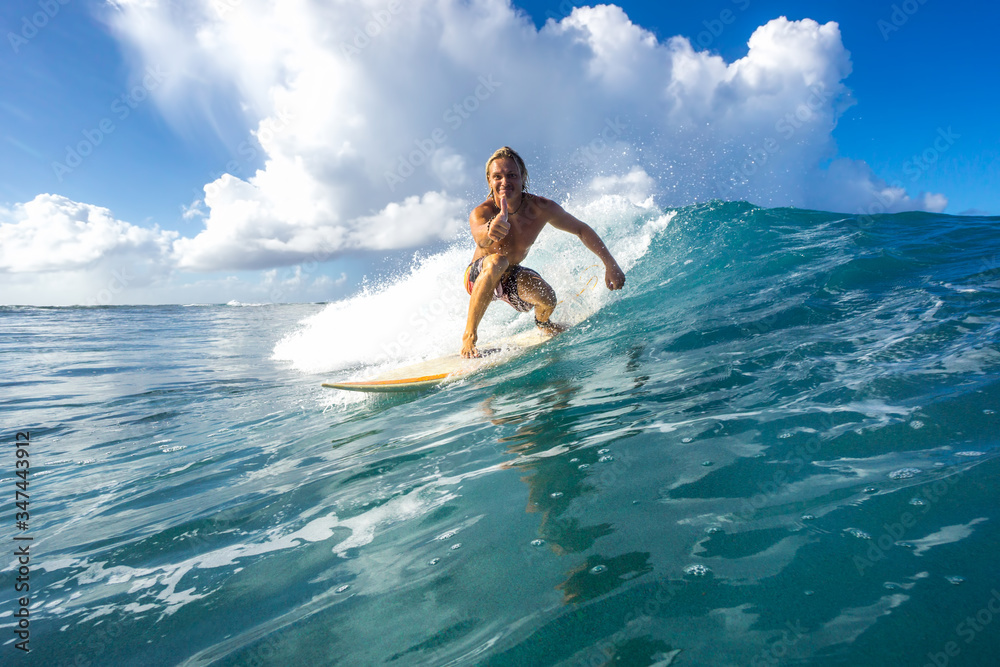 muscular surfer with long white hair riding on big waves on the Indian ...