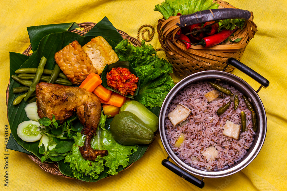 Indonesian traditional food nasi liwet with fried chicken, tahu, sambal ...