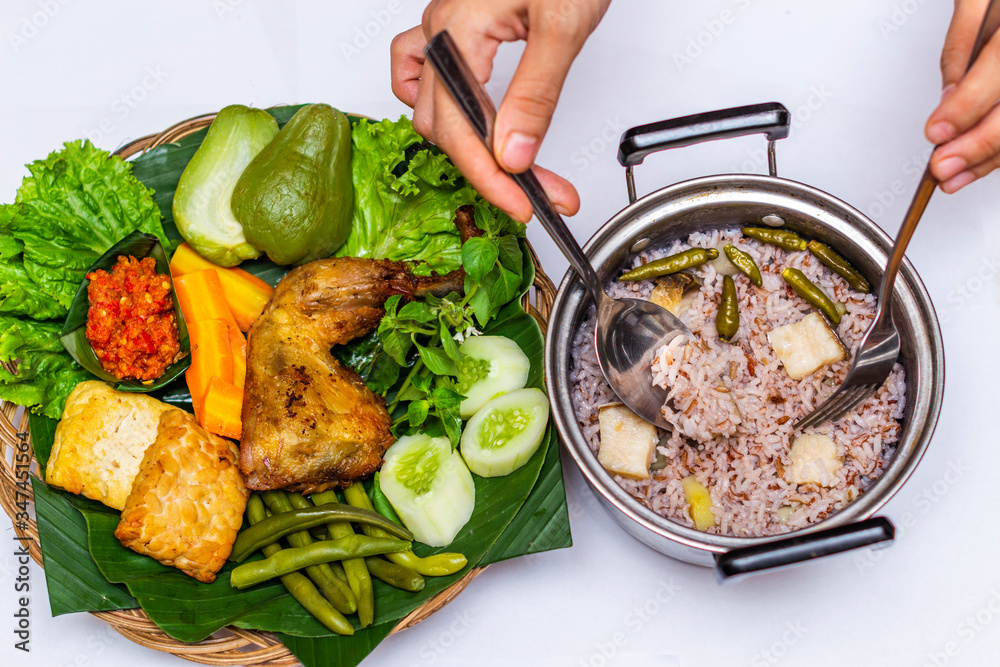 Indonesian traditional food nasi liwet with fried chicken, tahu, sambal ...