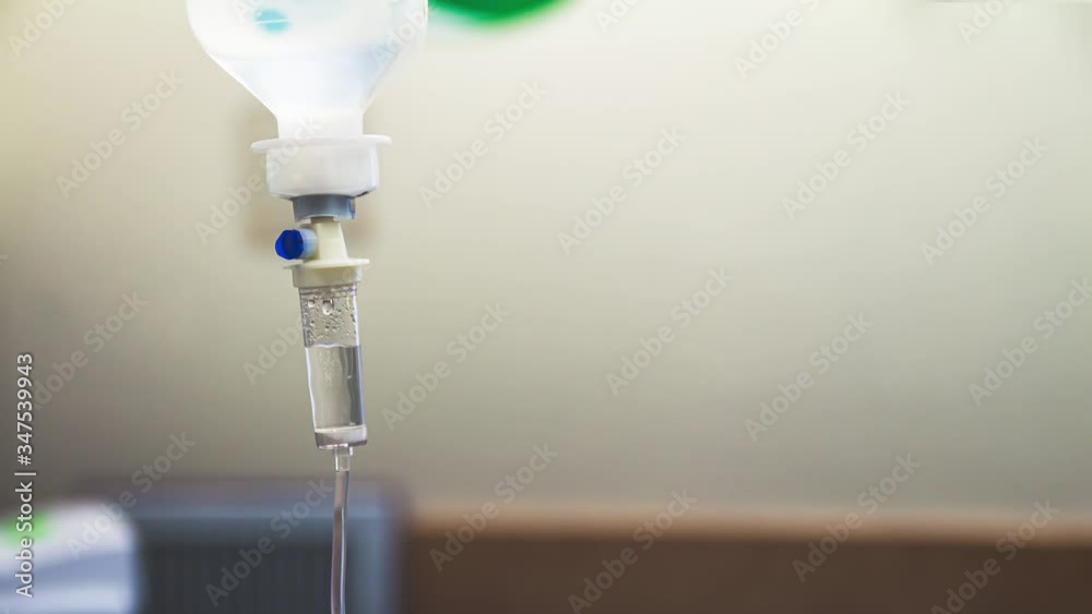 Cinemagraph of a fluid intravenous saline drip in a hospital room ...