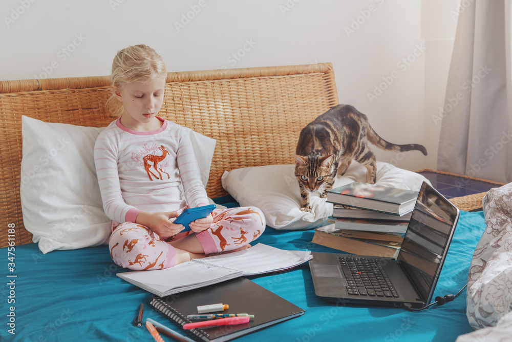 Caucasian girl child sitting in bed learning online counting on ...