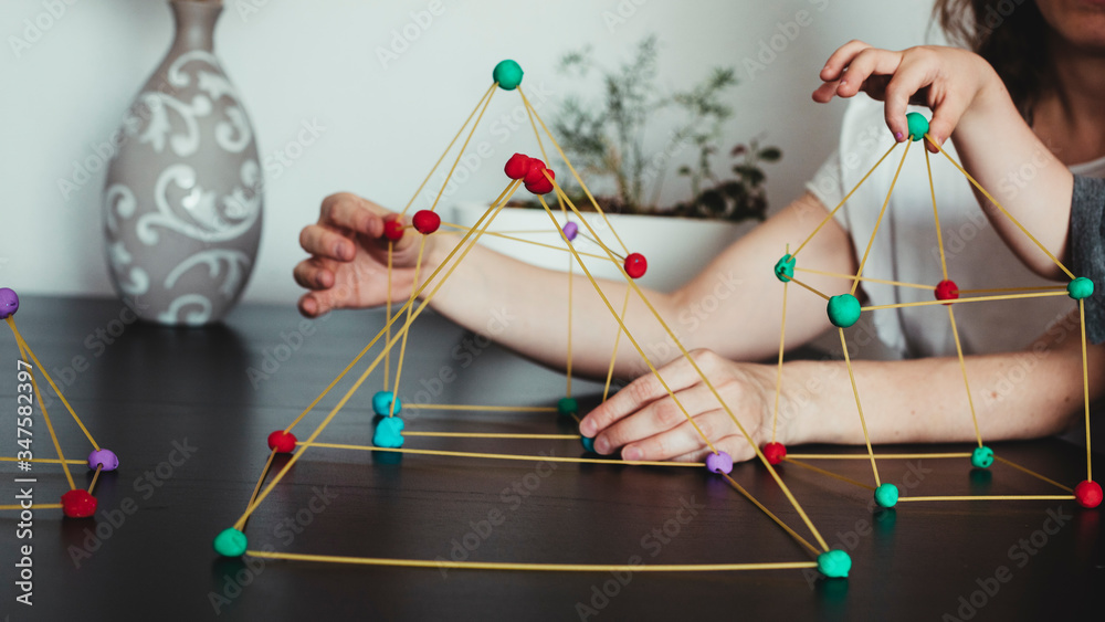 Mother and son making geometric shapes from sticks and play dough ...