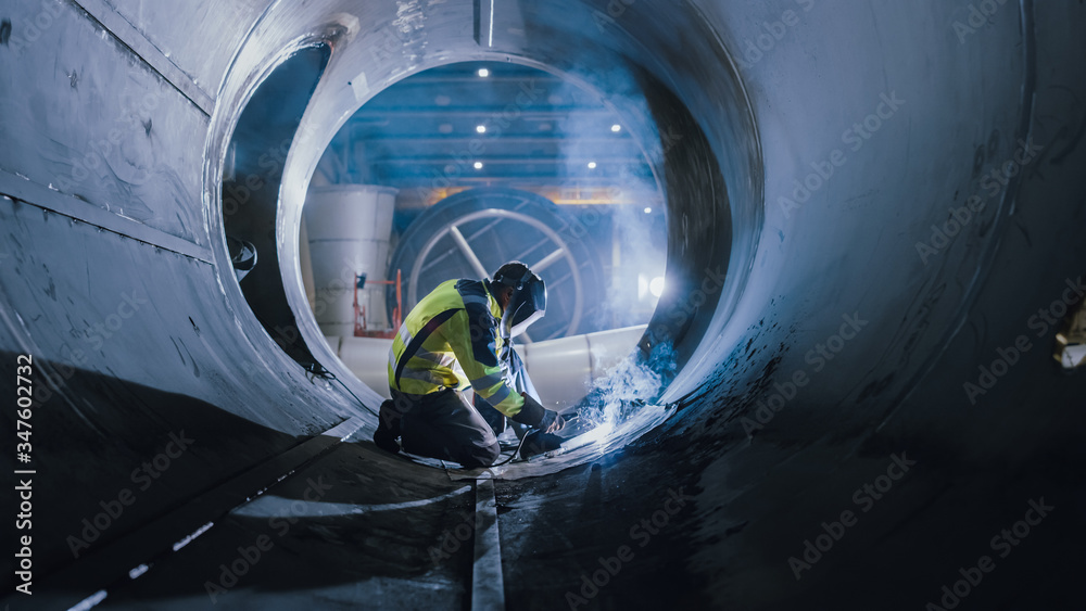 Professional Heavy Industry Welder Working Inside Pipe, Wears Helmet ...