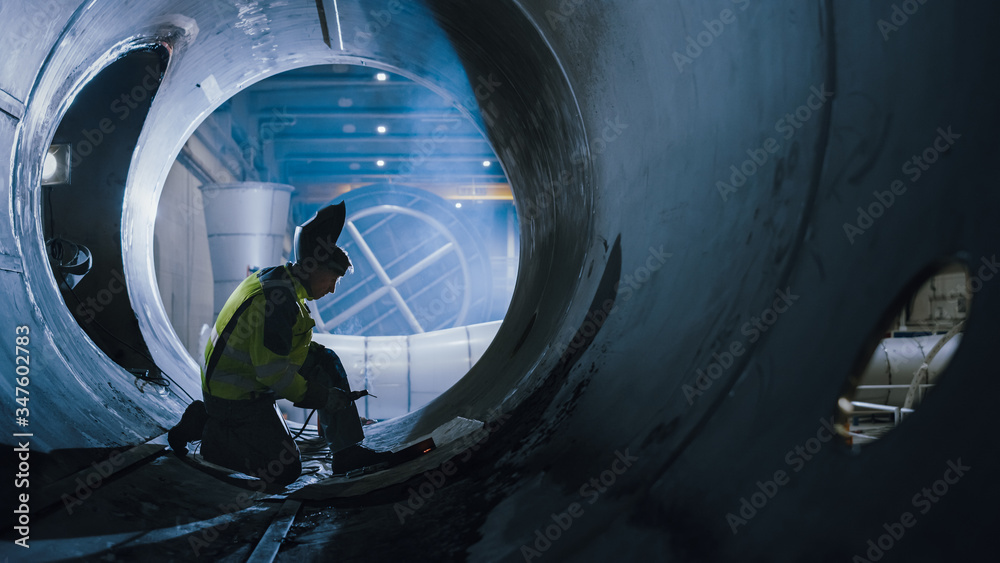 Professional Heavy Industry Welder Working Inside Pipe, Wears Helmet ...