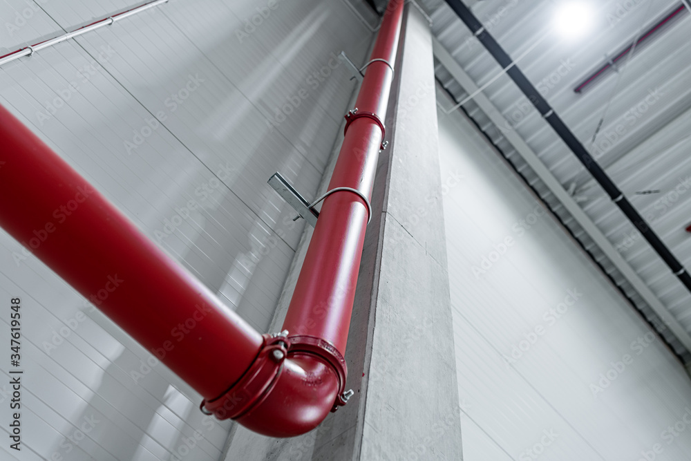 fire suppresion system in a empty industrial hall red pipes and bariers ...
