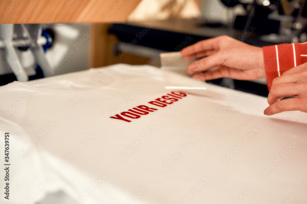 We bring print to life. Cropped shot of hand of woman removing the ...