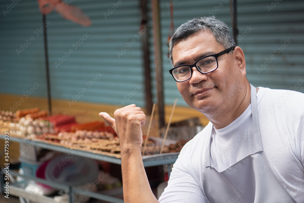 street hawker man working pointing thumb up to delicious meatball ...