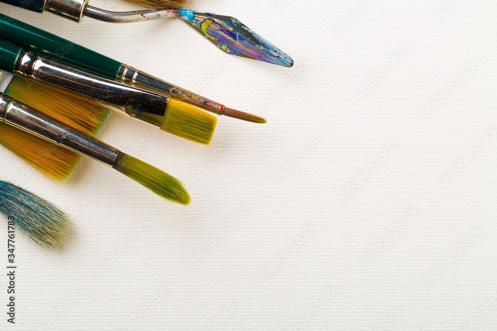 Artistic art supply utensils with brushes on white canvas background ...