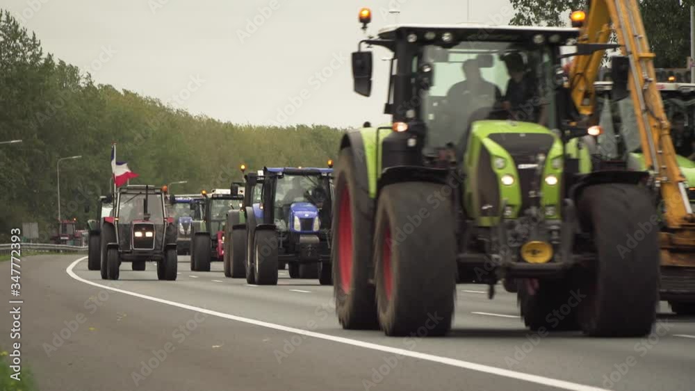Parade of tractors driving side by side on highway causing slow traffic ...