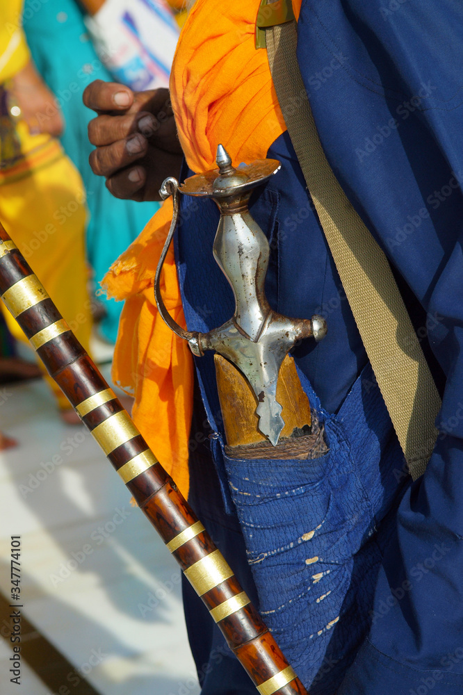 kirpan,sword of sikh people in traditional costume in the golden temple ...