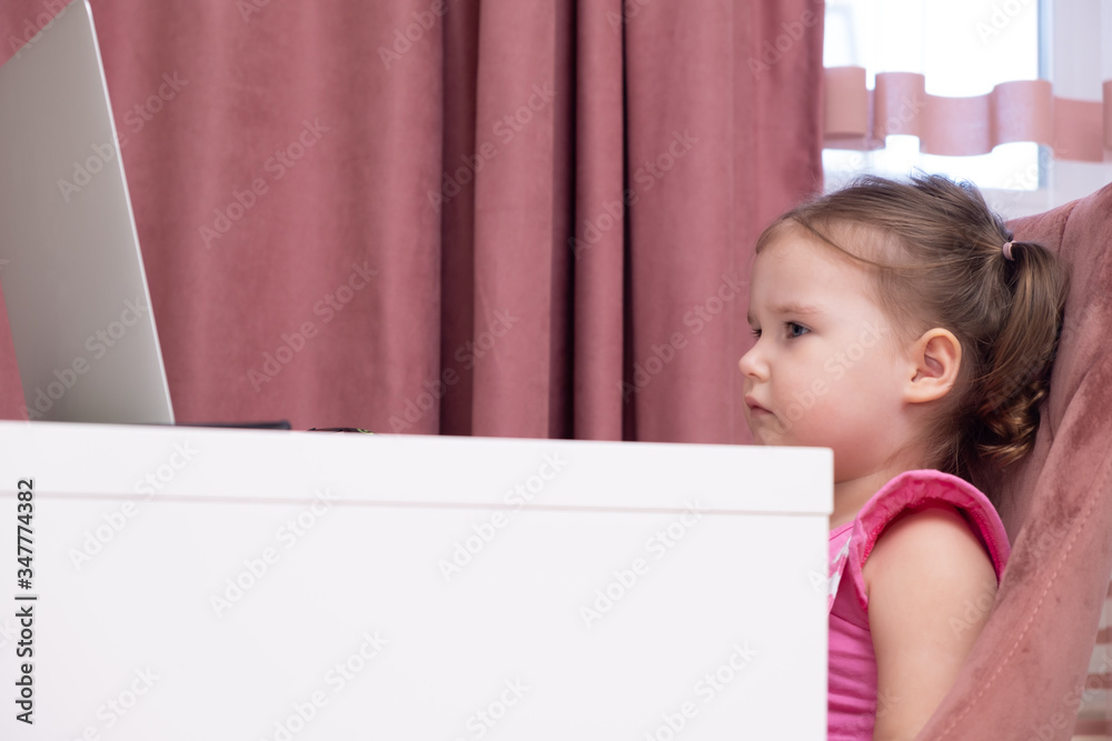 beautiful cute little girl behind laptop computer. The concept of ...