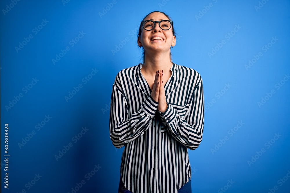 Beautiful blonde woman with blue eyes wearing striped shirt and glasses ...