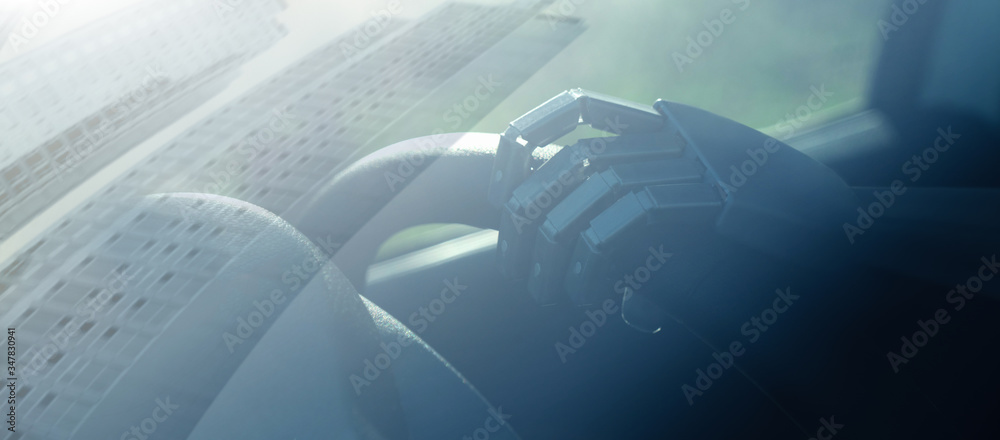Robot arm on a steering wheel. Artificial intelligence drives a car ...