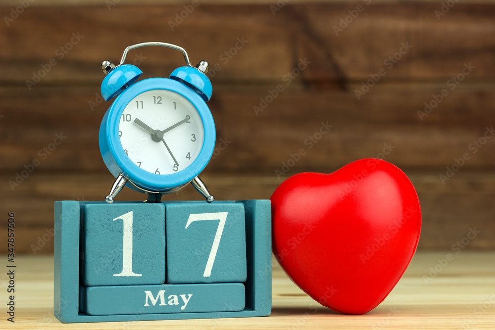 wooden calendar with the date of May 17, a clock and a red heart on a ...