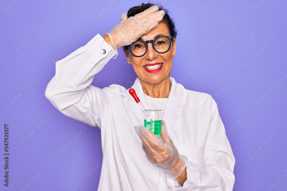 Middle age senior scientist woman wearing laboratory coat holding ...