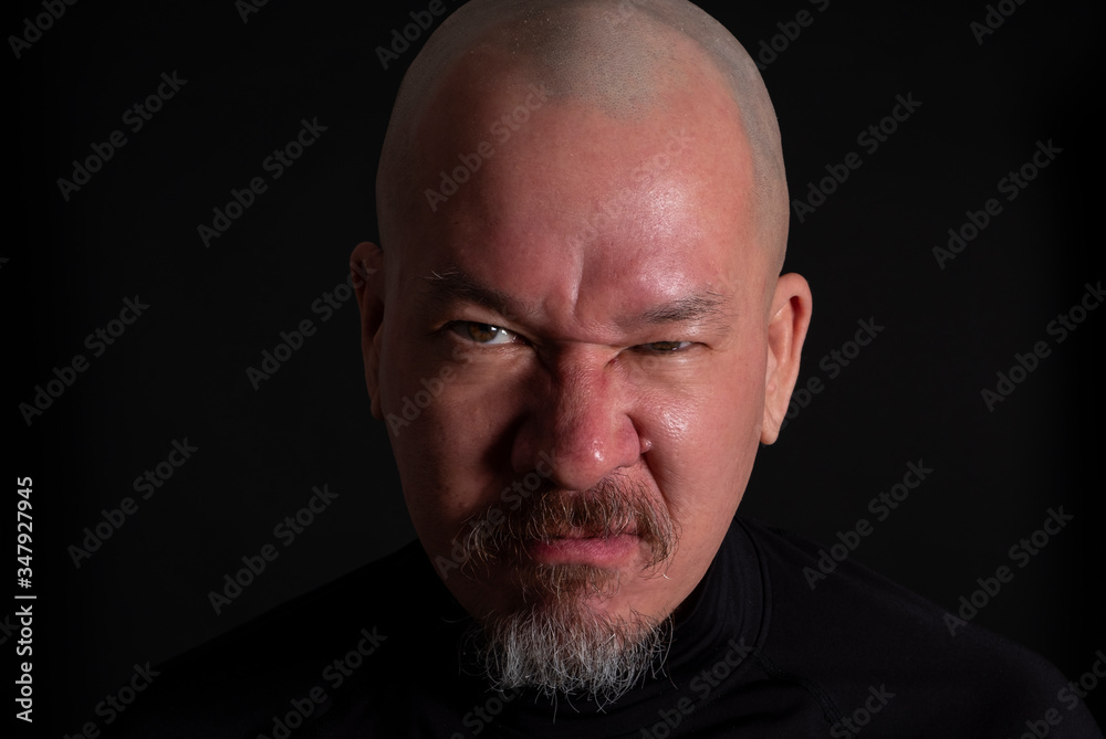 A Bald Man with Beard and an Angry Expression on His Face on Black ...