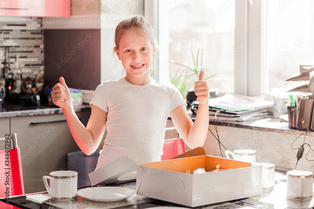 Food delivery. Girl at home in the kitchen stands next to a box of mini ...