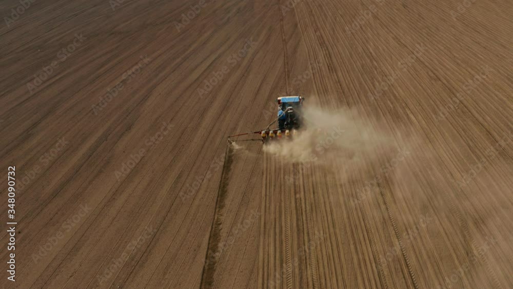 Tractor in the dust working in the field. Tractor with a modern sowing ...