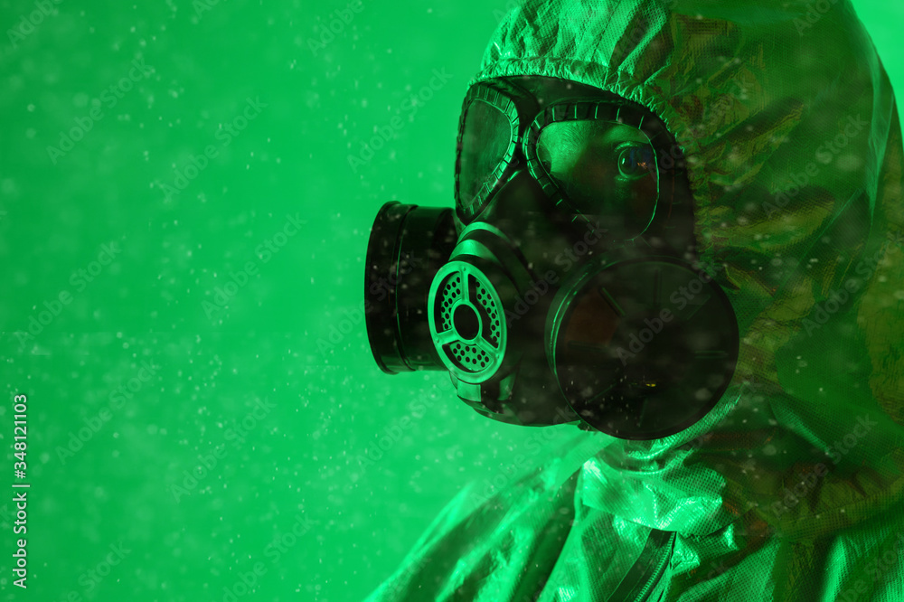 Portrait of a man in profile in a radiation suit and gas mask on a ...