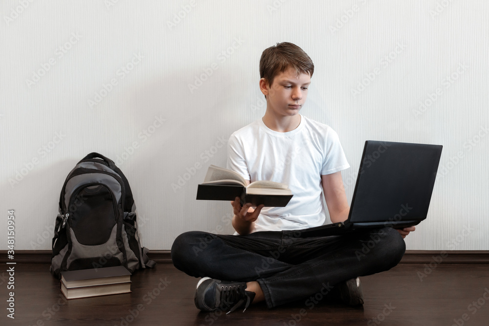 Foto de Student sitting on the floor with legs crossed and using laptop ...