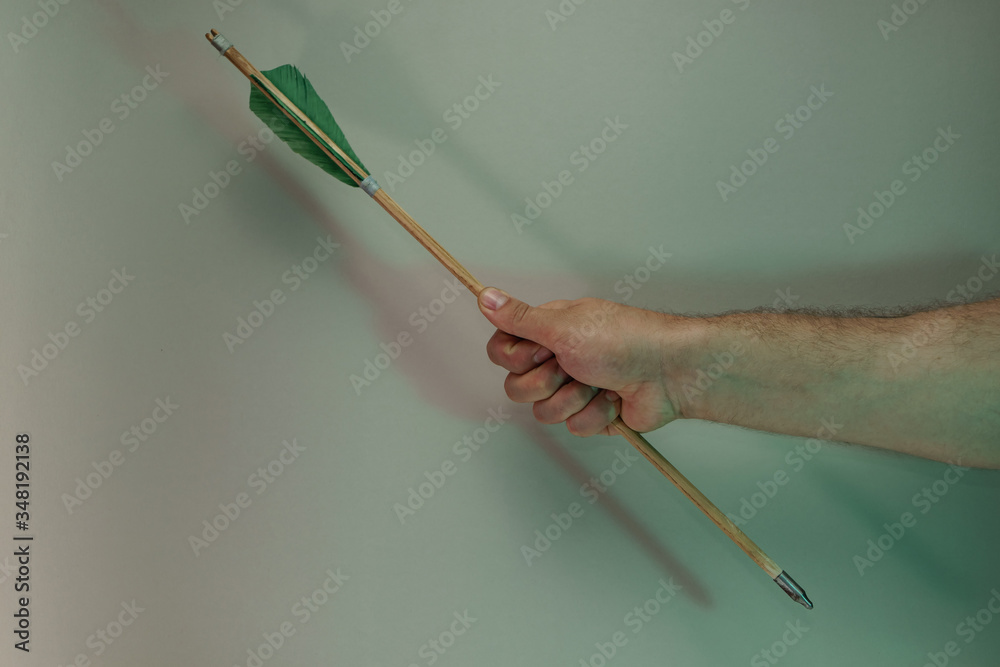 Hand holding old green arrows in the color light. Beautiful old arrow ...