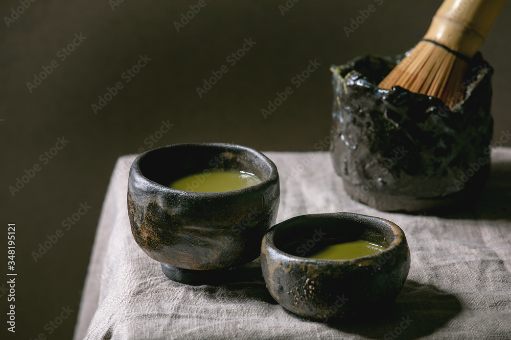 Japanese matcha green tea in two wabi sabi cups, bamboo whisk on grey ...