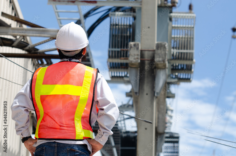 Electrical engineers standing at the job site with a transformer ...