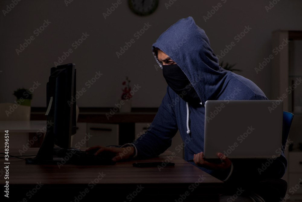 Male hacker hacking security firewall late in office Stock Photo ...