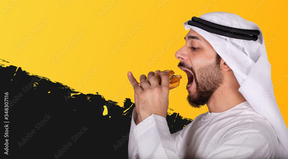 Side view of close-up portrait of young Arab man eating a burger ...