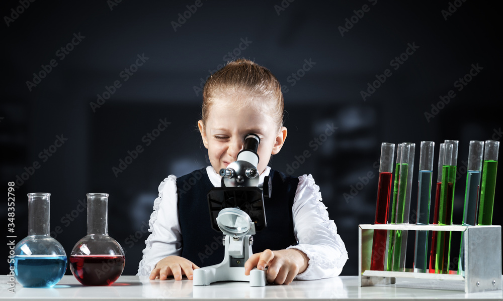 Little scientist looking through microscope Stock Photo | Adobe Stock