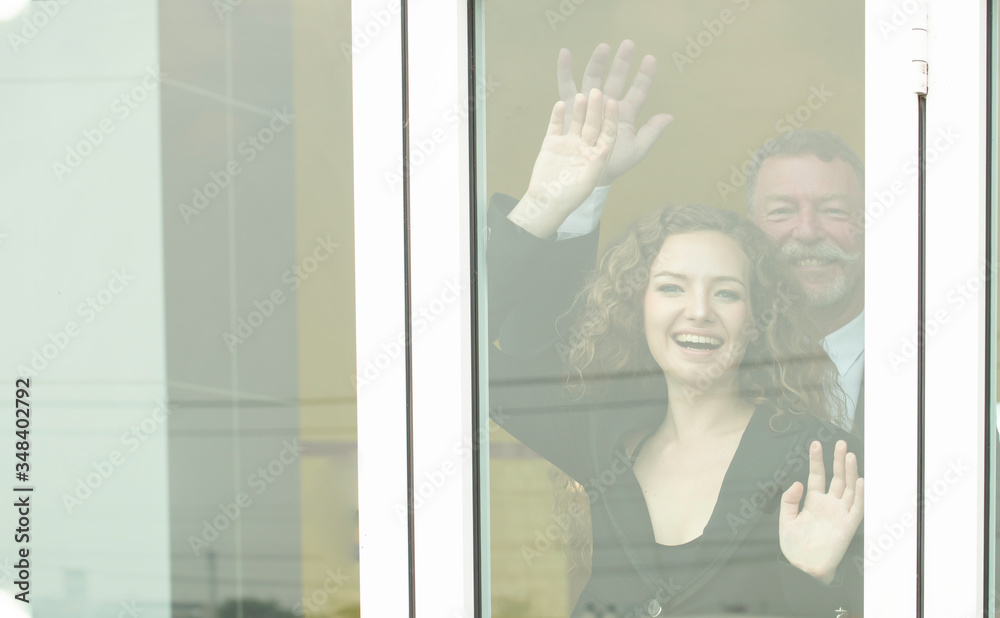 Business middle aged man and beautiful woman behind their glass window ...