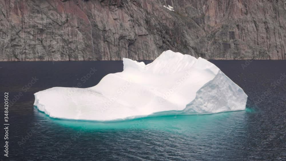 Iceberg floating surrounded by snow capped mountains in Prince ...