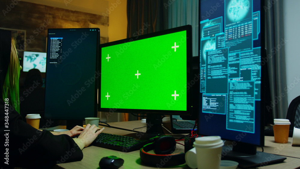 Zoom in shot of hacker girl in front of computer with green screen ...
