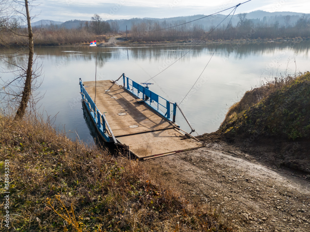 Ferry for transporting goods and people across the river moored along ...