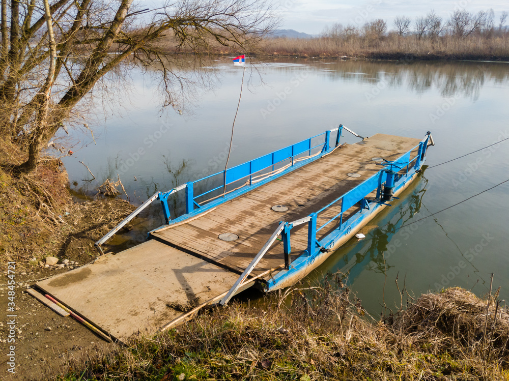 Ferry for transporting goods and people across the river moored along ...