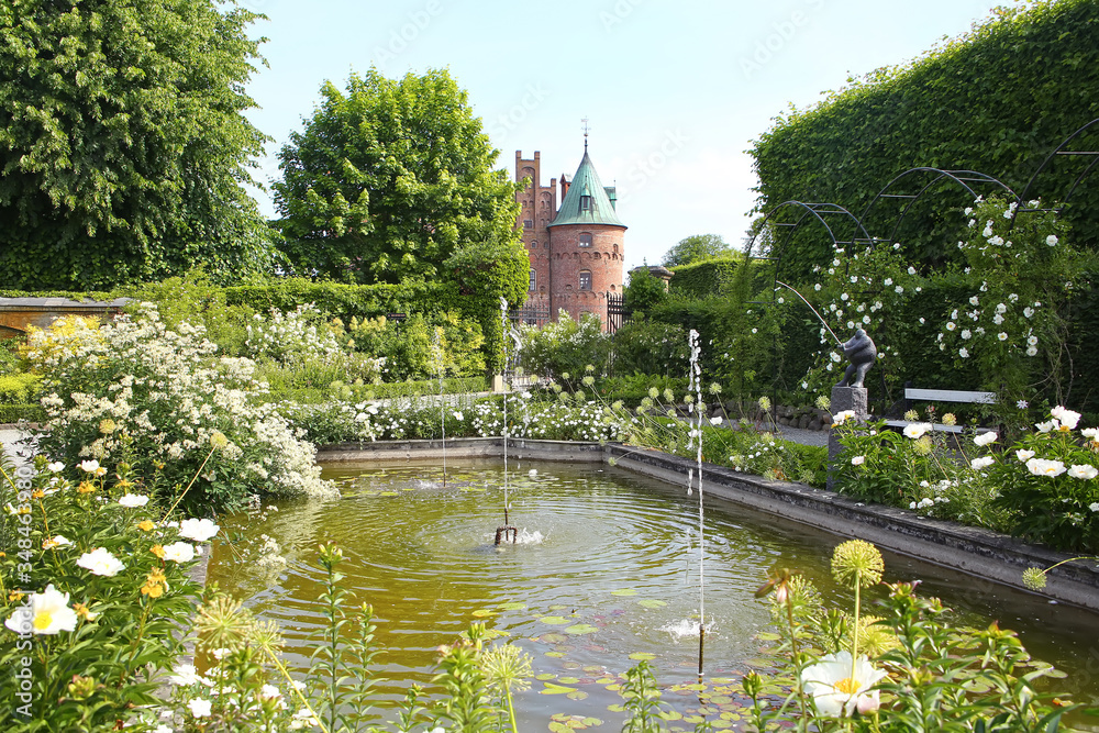 Traditional formal public garden, in bloom in the summer with a lake ...
