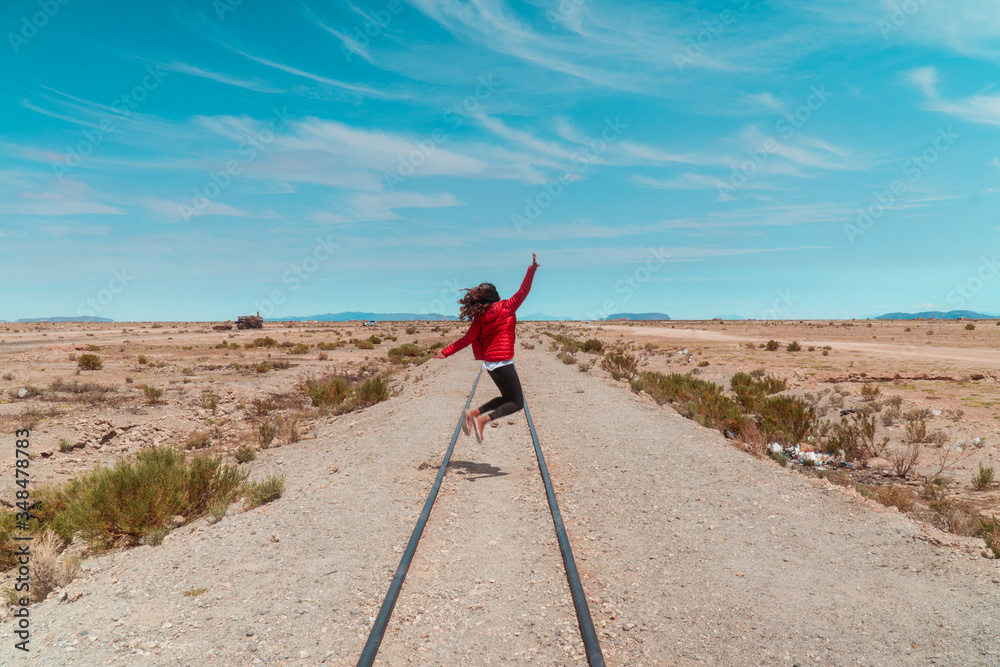 Tourist jumping, Train track lines. Bolivia Salt Flats. Bolivian salty ...
