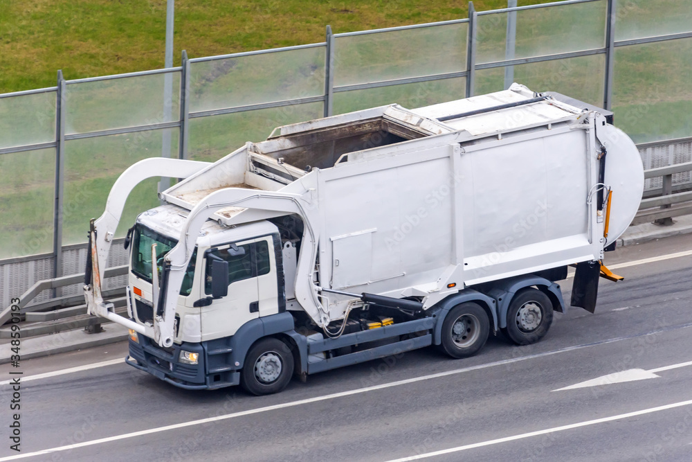 Garbage truck for the transportation of waste goes on city road. Stock ...