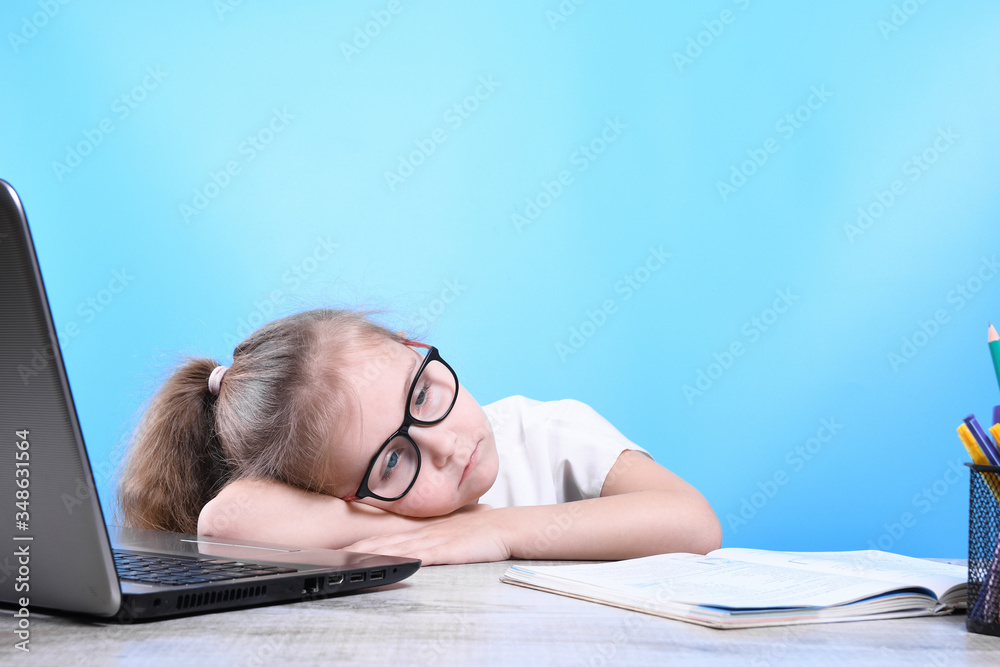Back to school .Happy cute industrious child is sitting at a desk ...