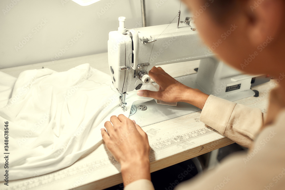 Life In Every Stitch. Close up of seamstress hands. She is sitting and ...
