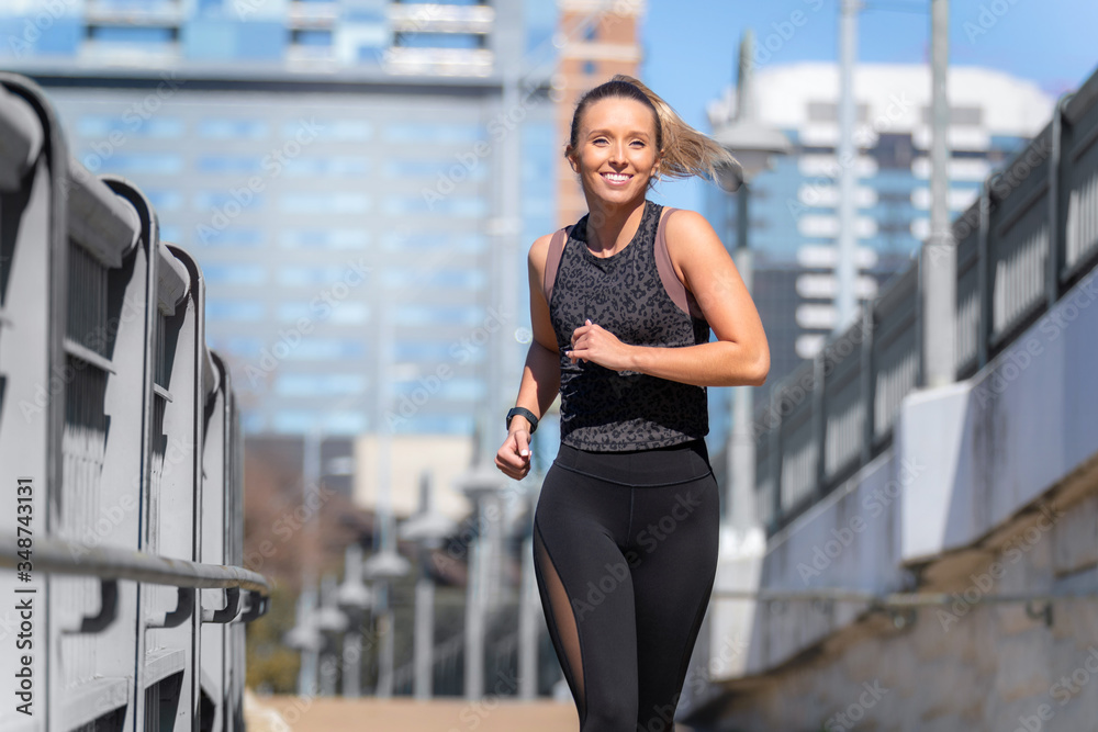 Thin, slim, fit woman exercising running in urban city background ...