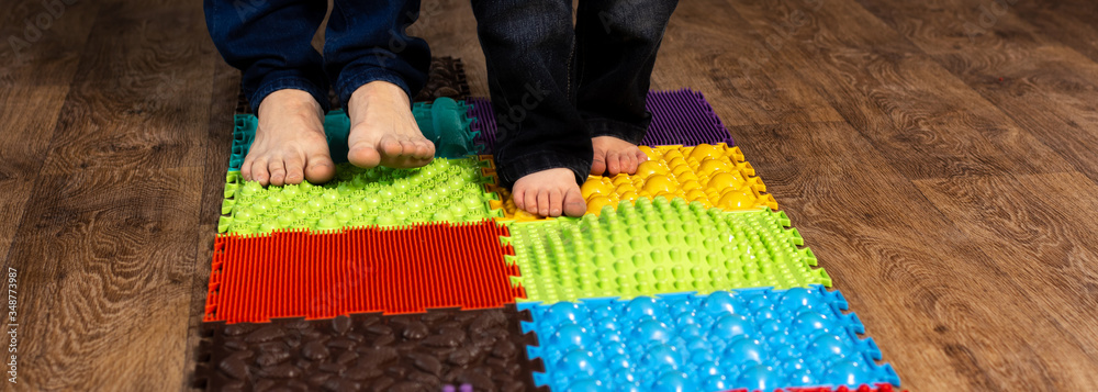 adult and children's feet on orthopedic rug close-up. panoramic photo ...