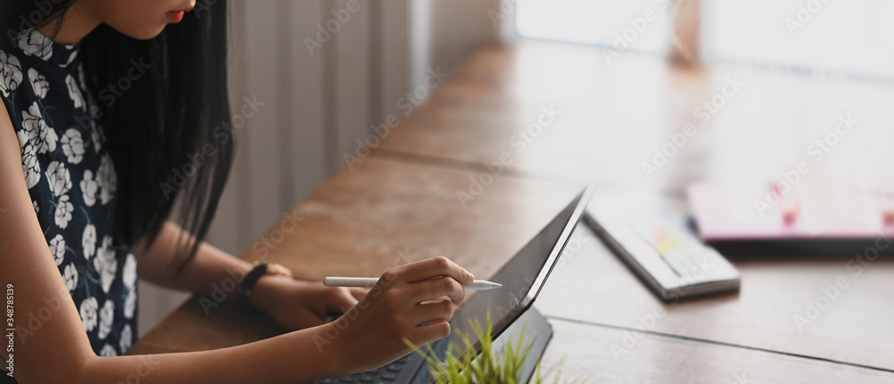 Cropped image of graphic designer writing/sketching on computer tablet ...