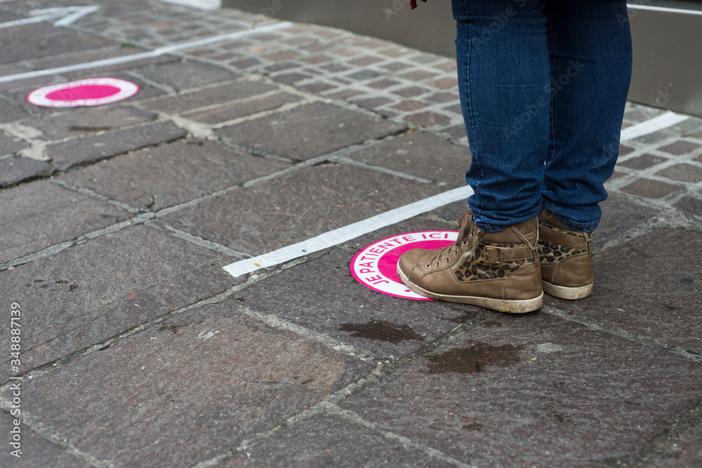 Closeup of feet of woman standing in the social distancing symbol on ...
