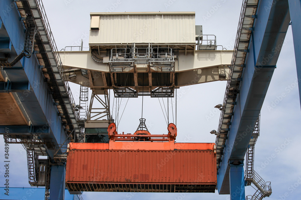 Transtainer crane moving a Shipping Container to a storage platform ...