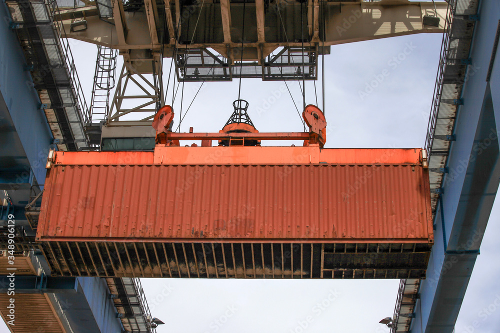 Transtainer crane moving a Shipping Container to a storage platform ...