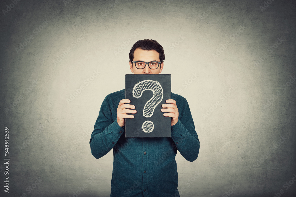 Unsure businessman looks to camera, holding a board with a drawn ...